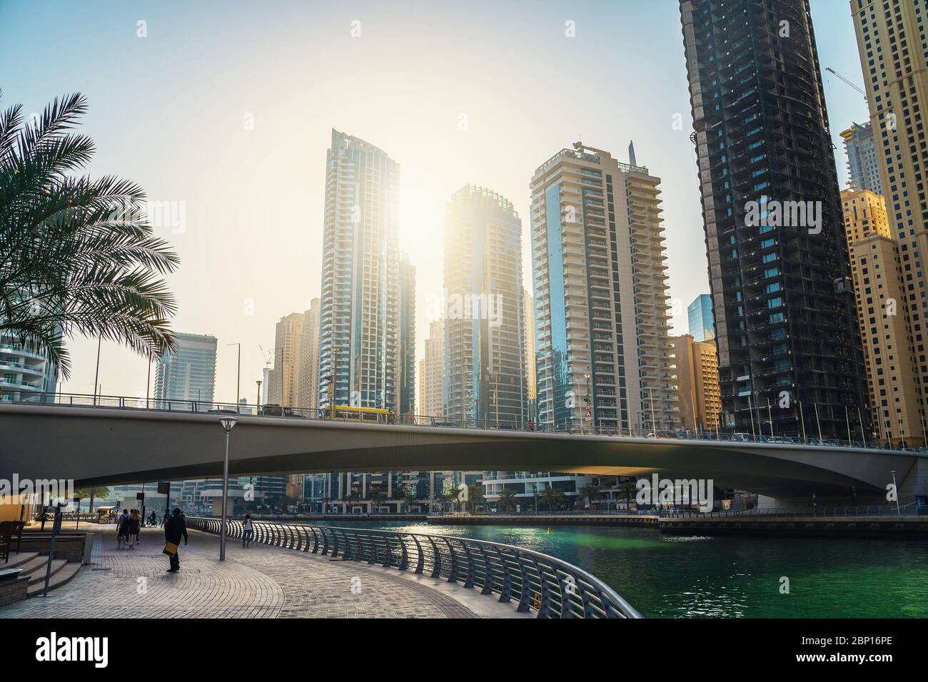 Dubai Marina promenade with walking path, canal with boats and high ...