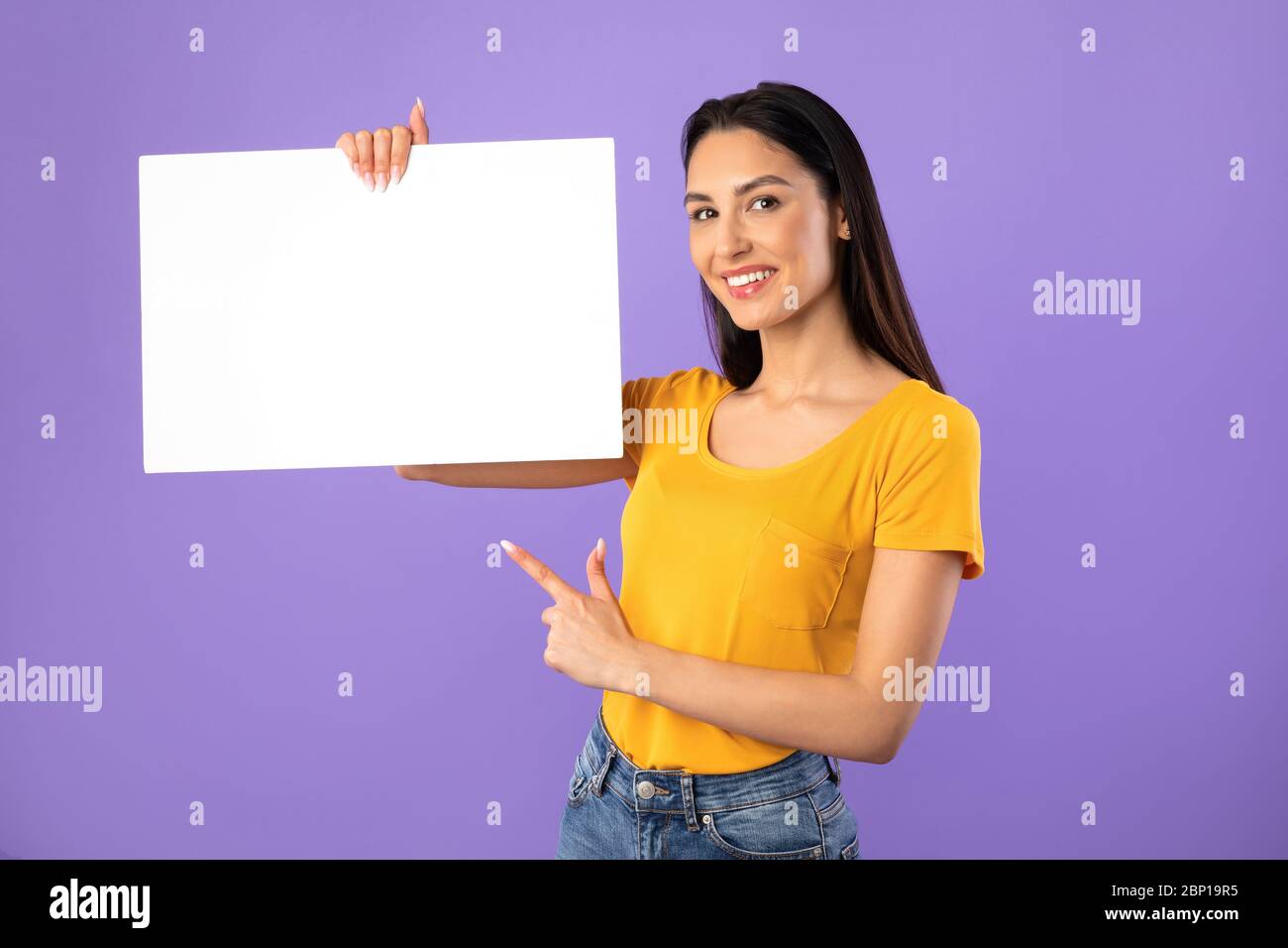 Happy young girl pointing at white paper Stock Photo - Alamy