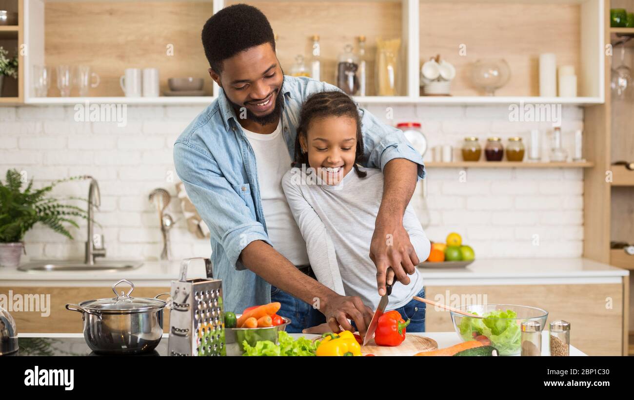 Cute little girl enjoying cooking dinner with lovely daddy Stock Photo ...