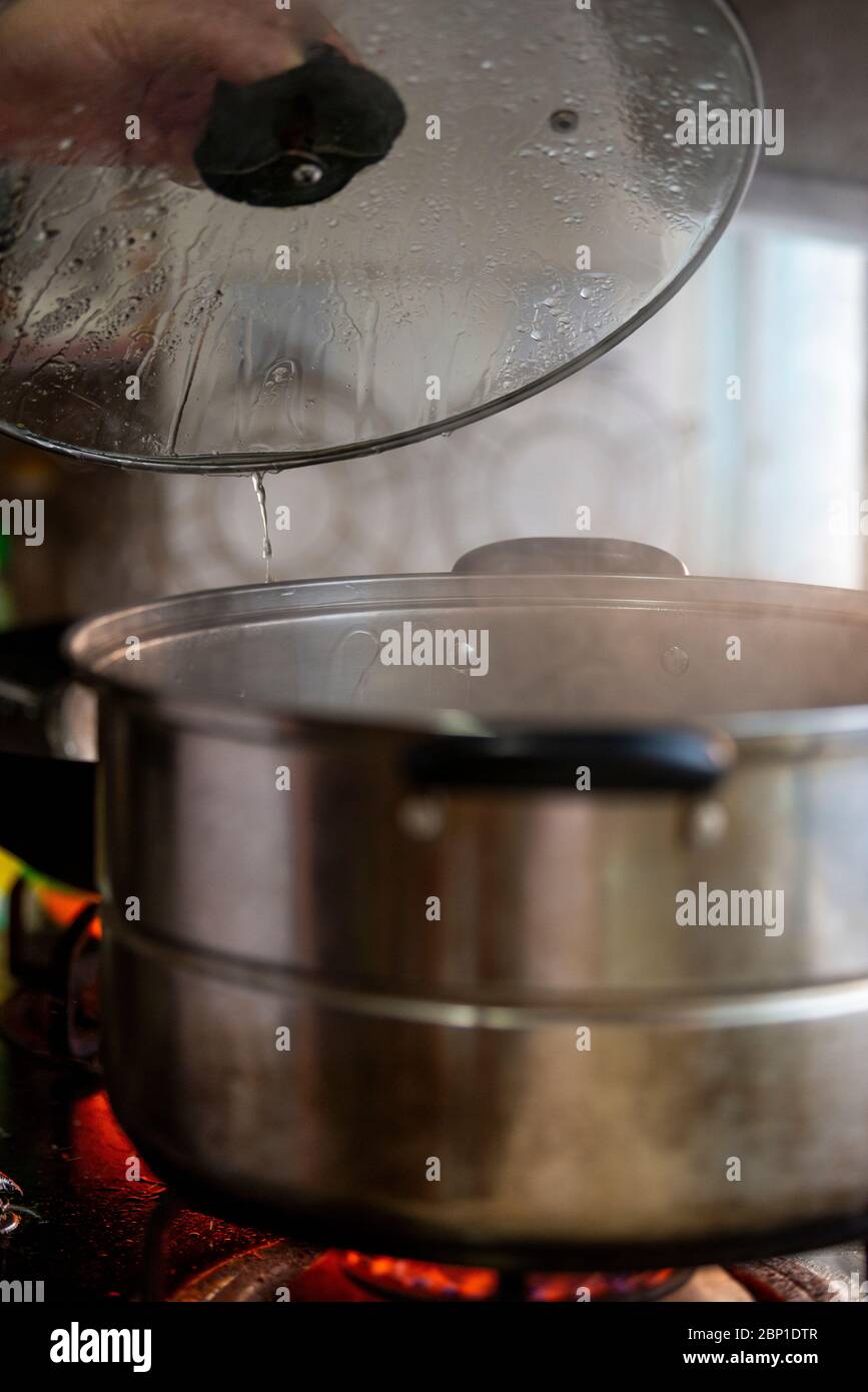 Uncovering a boiling deep pan in the Chinese family kitchen Stock Photo ...