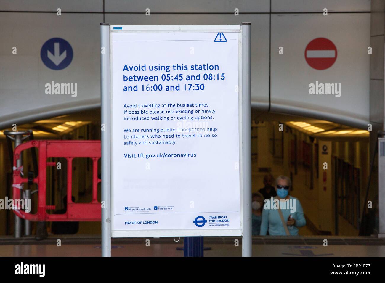 May 2020: Essential workers walk past public health information posters ...