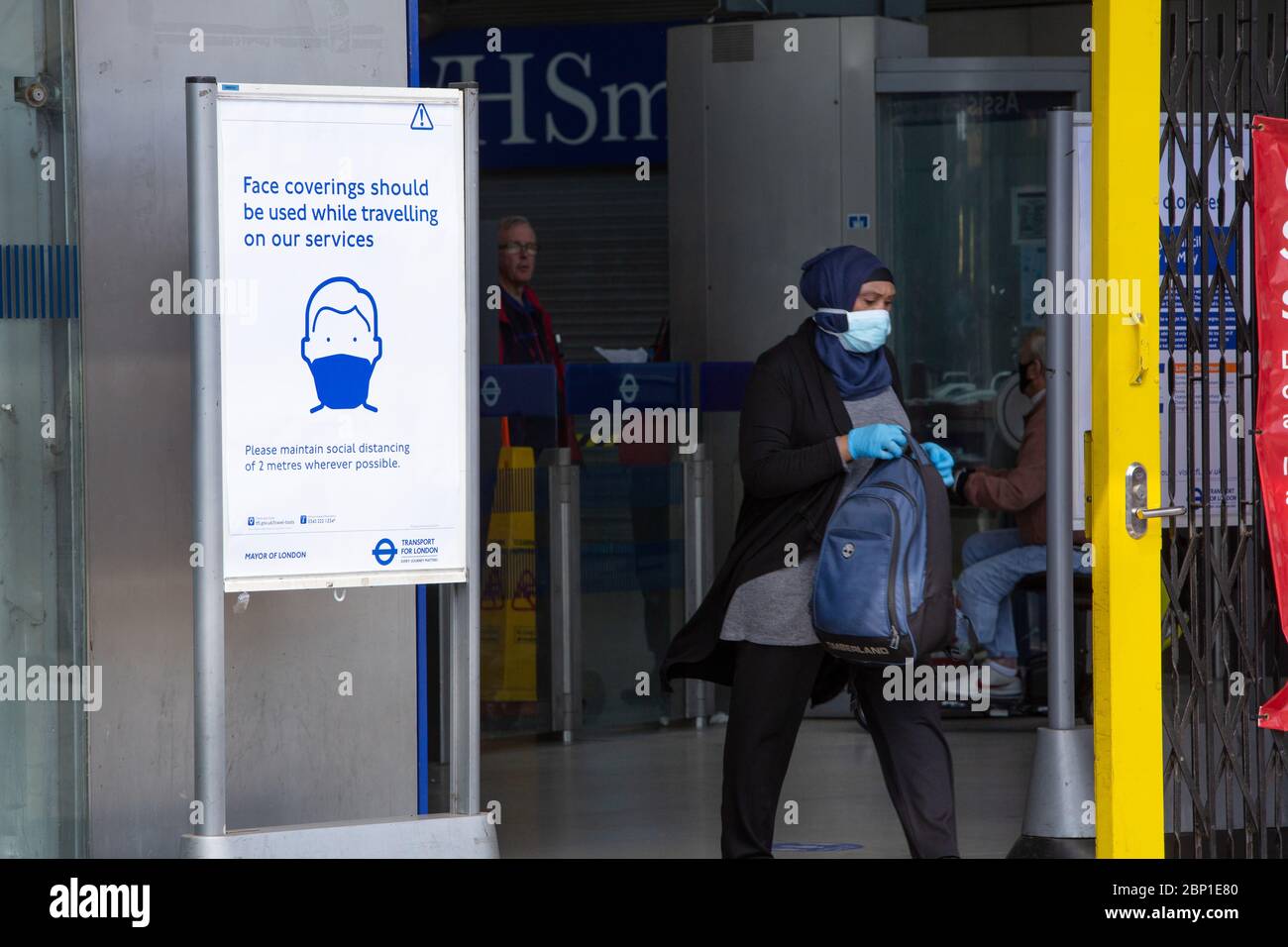 May 2020: Essential workers walk past public health information posters ...