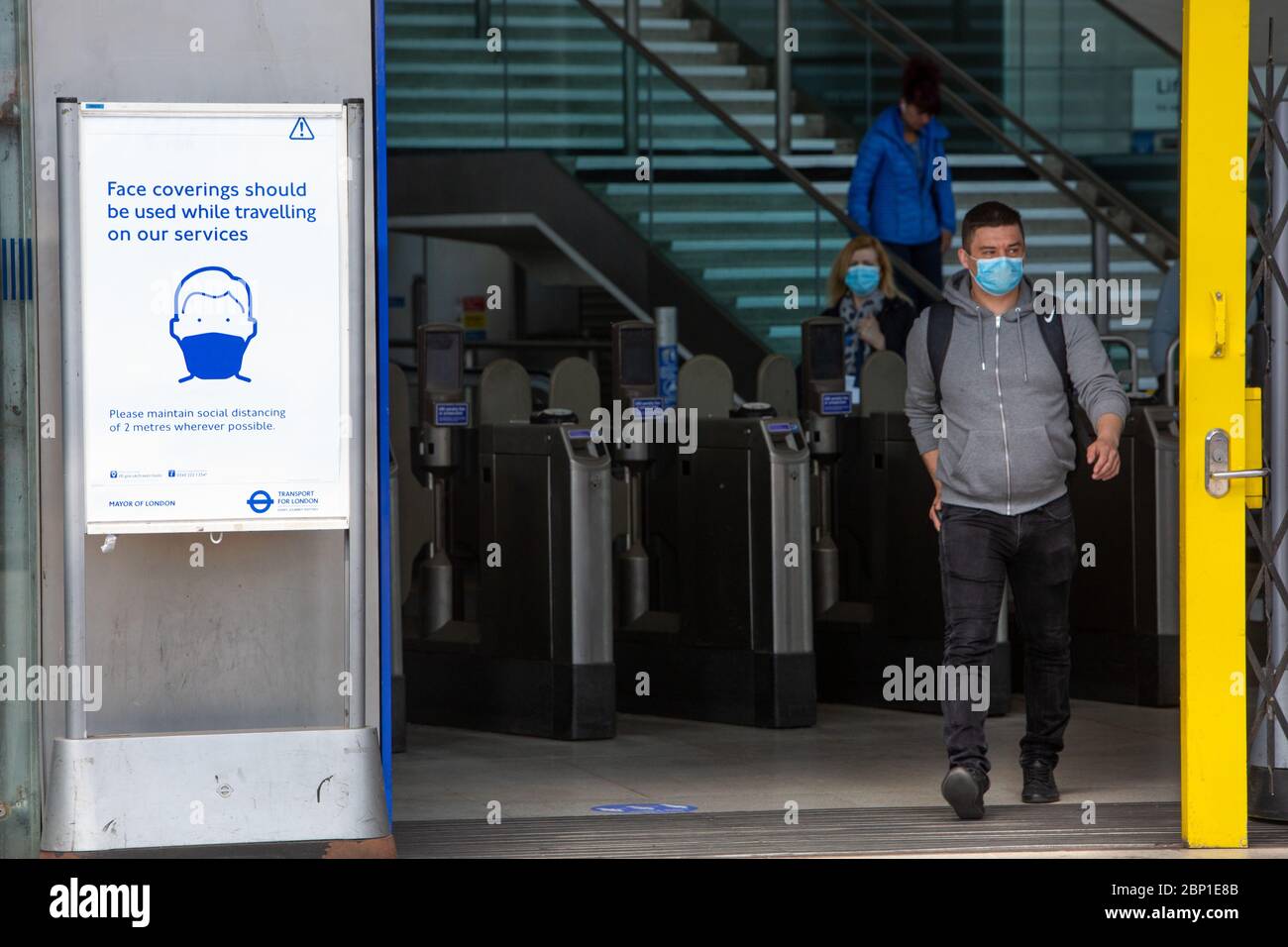 May 2020: Essential workers walk past public health information posters ...