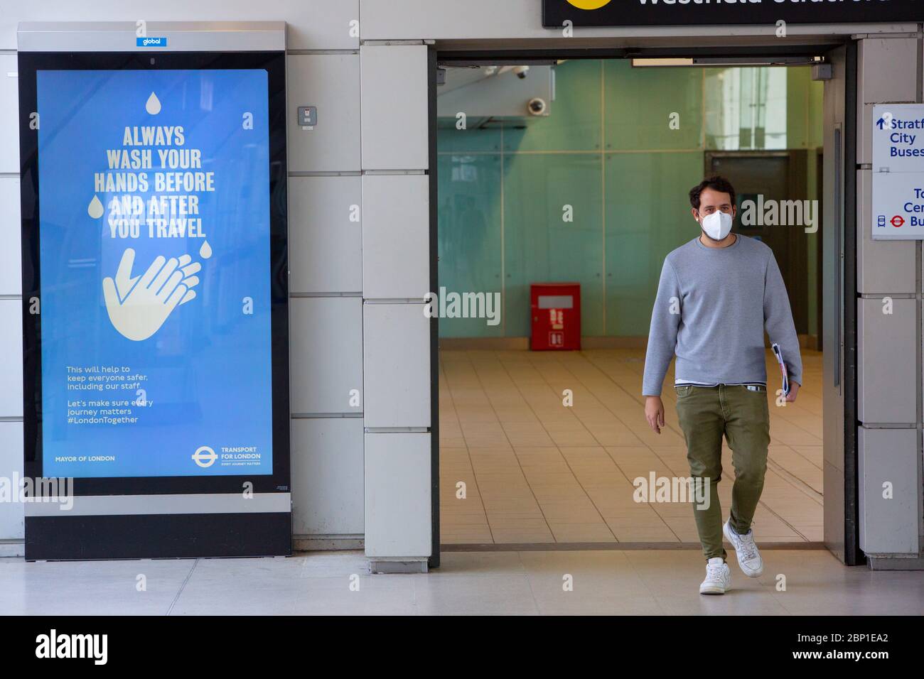May 2020: Essential workers walk past public health information posters ...