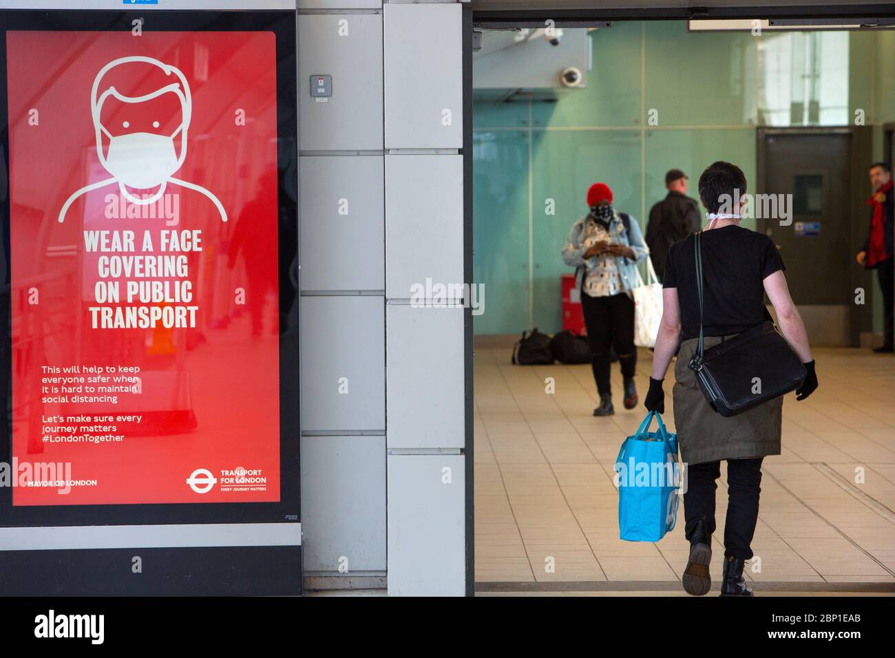 May 2020: Essential workers walk past public health information posters ...