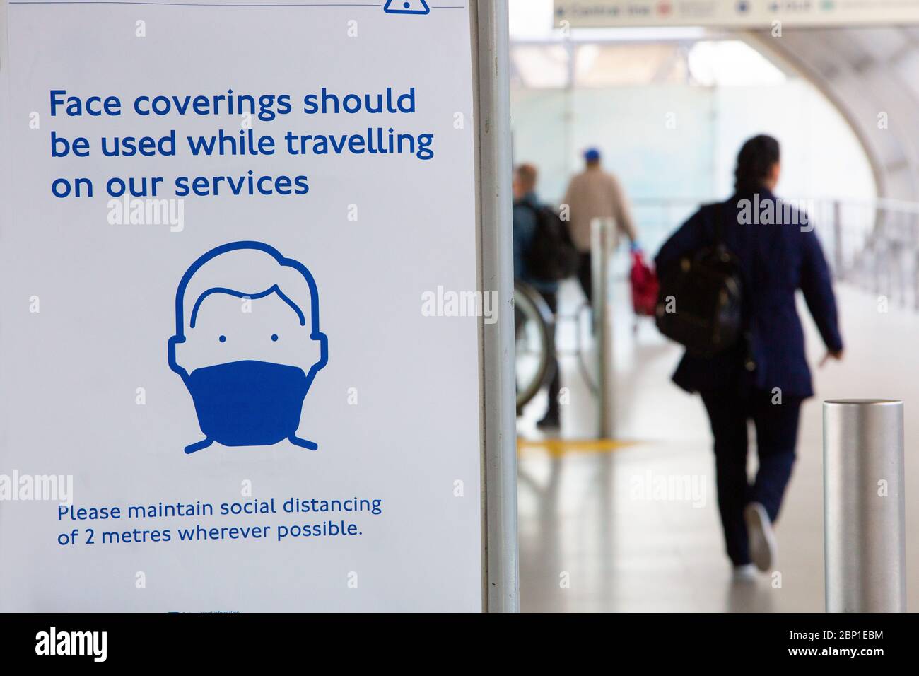 May 2020: Essential workers walk past public health information posters ...