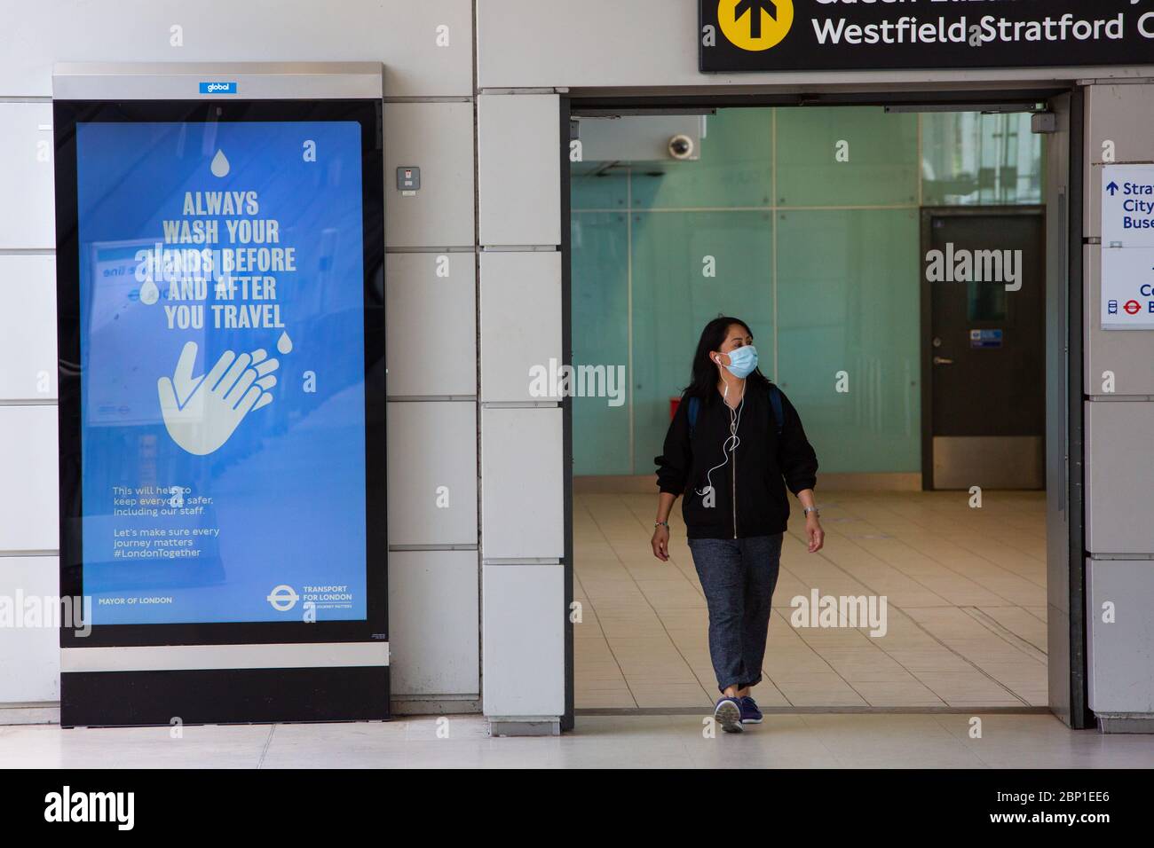 May 2020: Essential workers walk past public health information posters ...