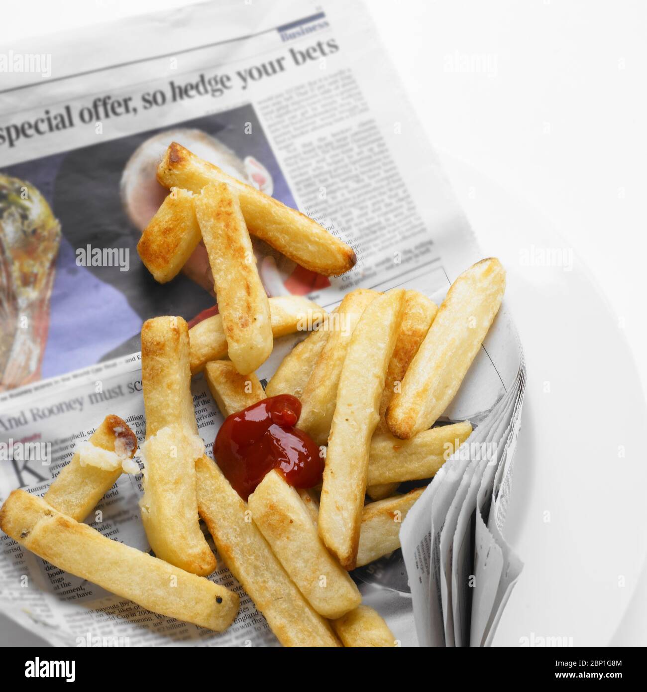 Chips wrapped in a newspaper with ketchup Stock Photo - Alamy
