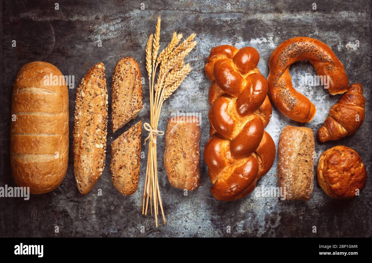 Fresh bakery food. Crusty loaves of mixed breads and buns and ears of ...