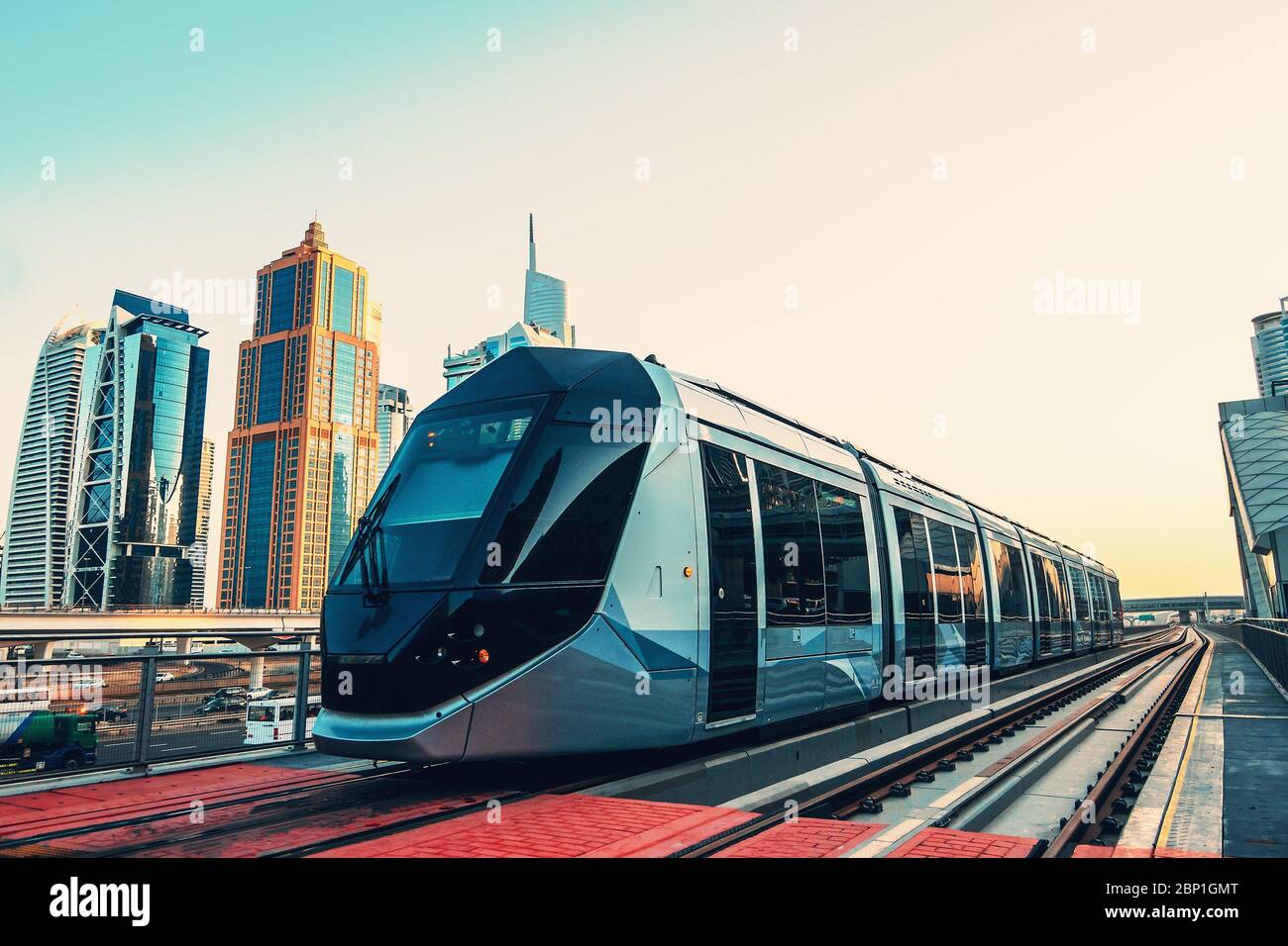 Metro train on rail line in Dubai downtown with skyscrapers at ...