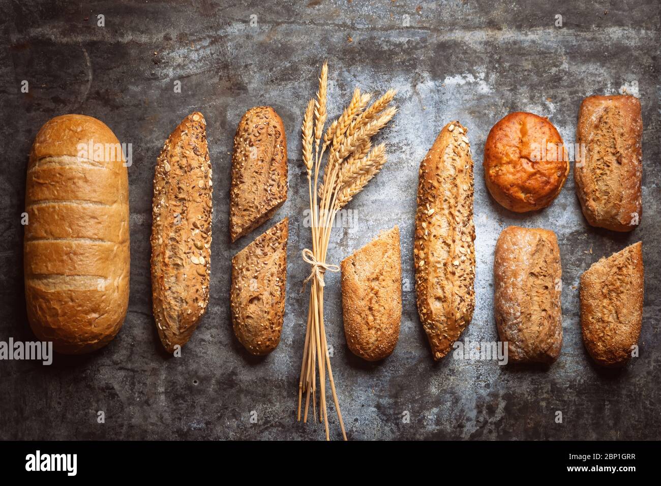 Fresh bakery food. Crusty loaves of mixed breads and buns and ears of ...
