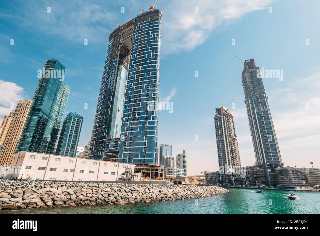 Dubai Marina with skyscrapers under construction in sunny day, United ...