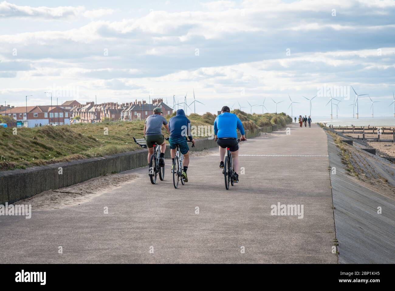 Three men cycle along the promenade at Redcar, Cleveland Stock Photo ...