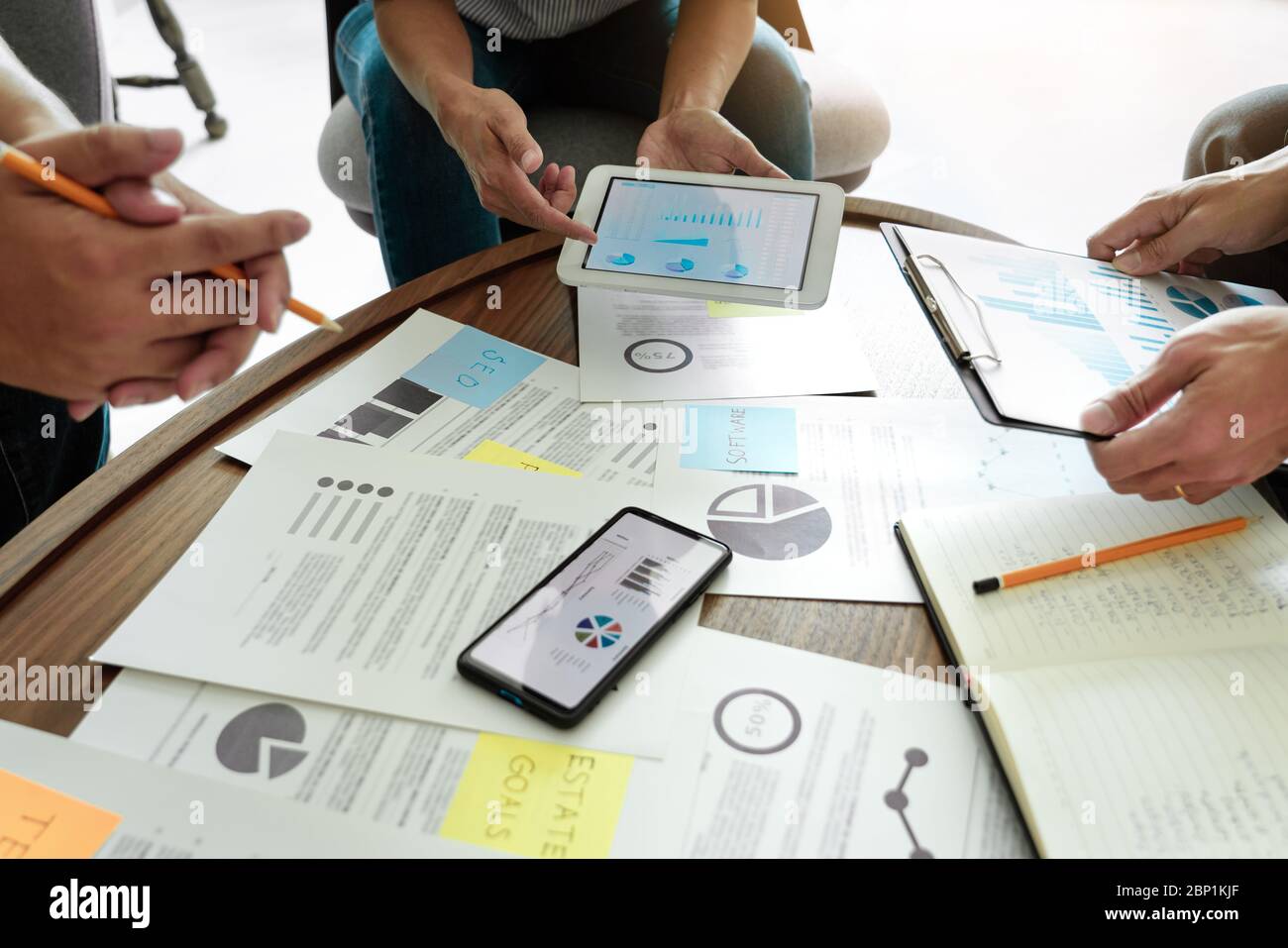 Business people writing on sticky notes for colleagues thinking ...