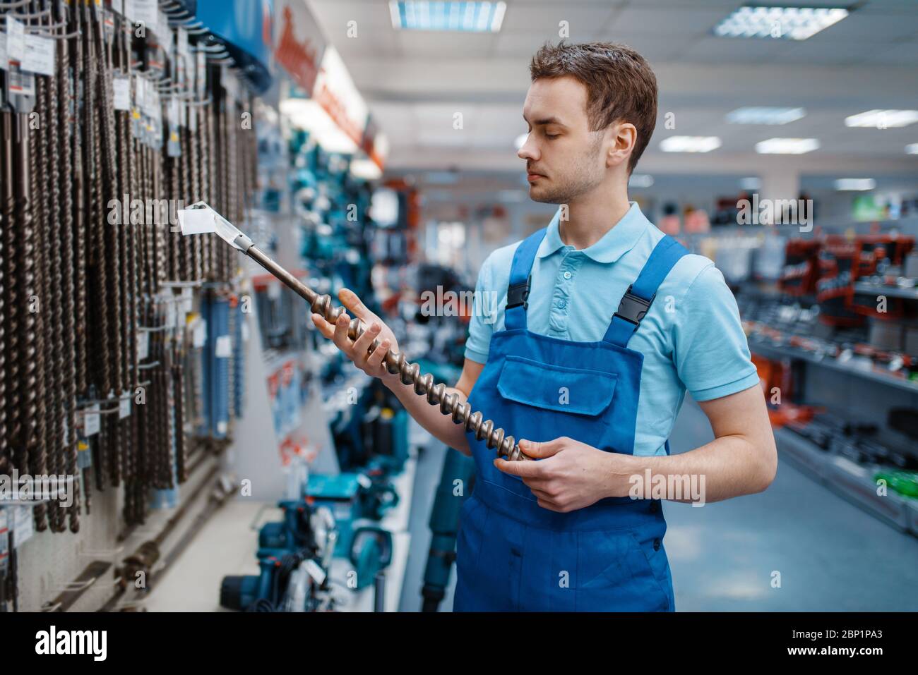 Employee choosing concrete drill in tool store Stock Photo - Alamy