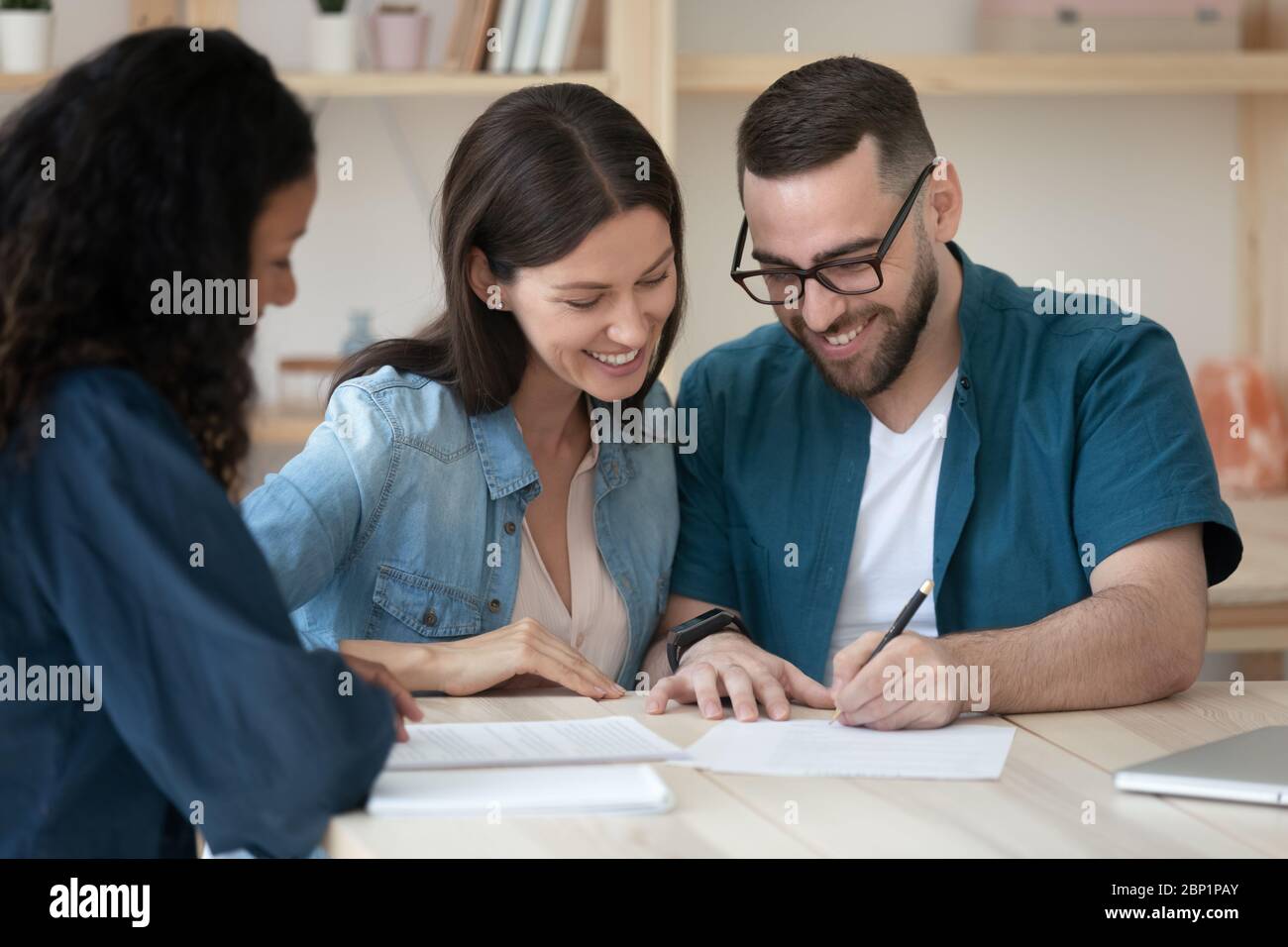 Happy young couple clients make purchase deal sign insurance contract ...