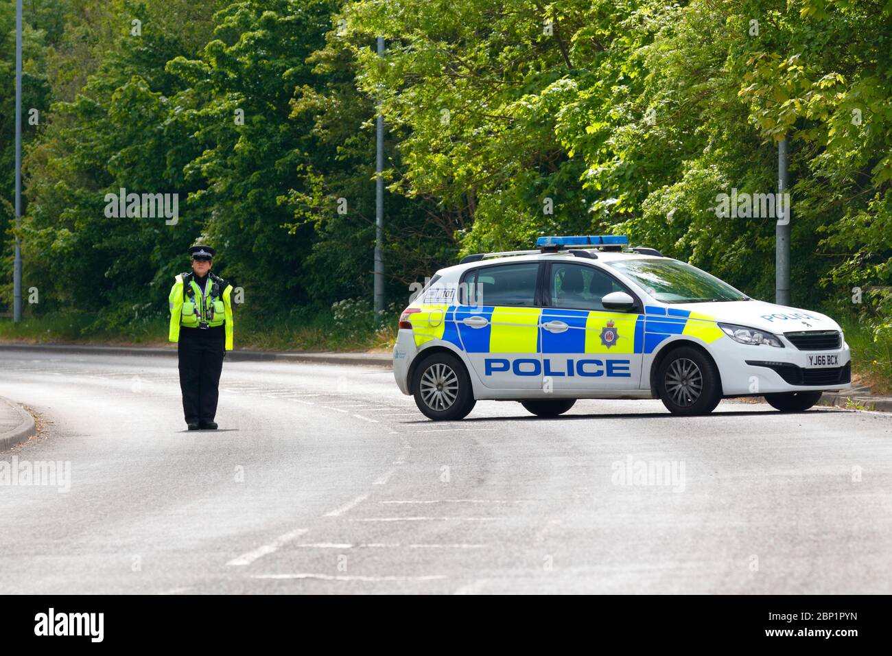 A Police officer acts as a road block to divert traffic away from a ...