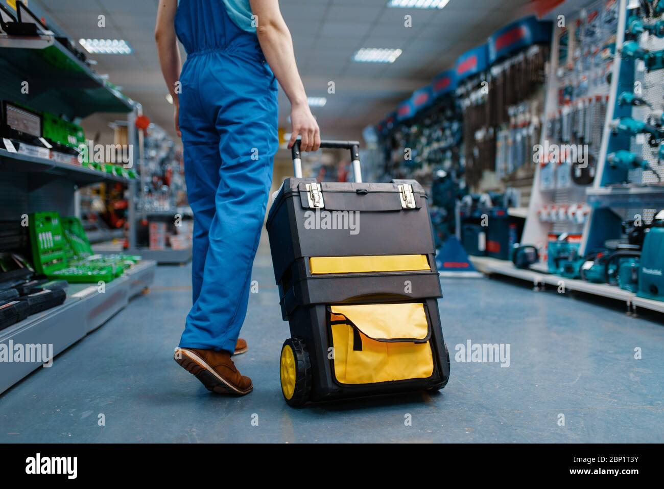 Male worker holds toolbox on wheels in tool store Stock Photo - Alamy