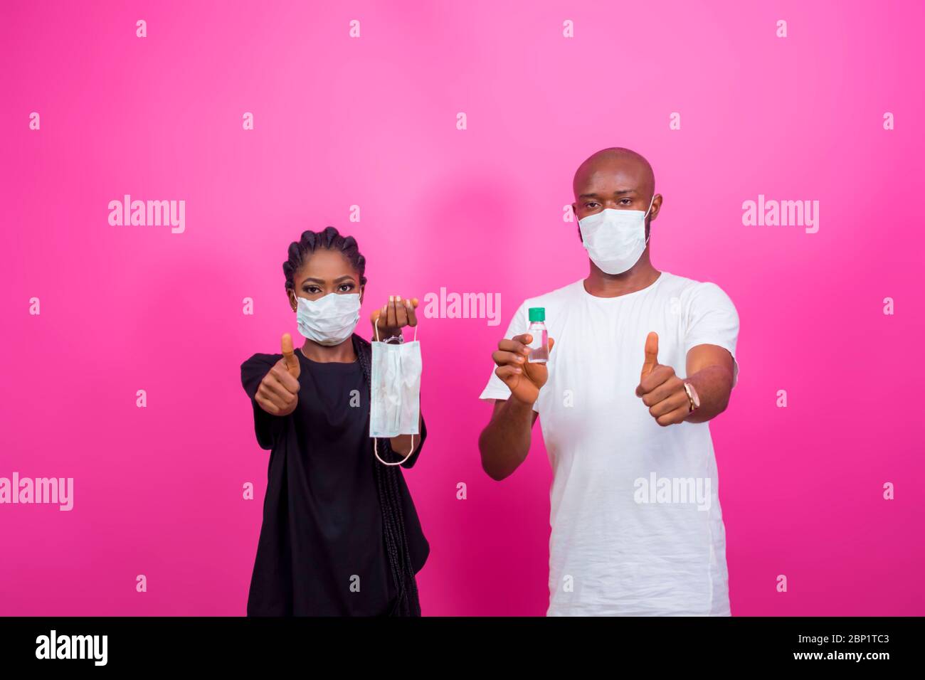 young black man and woman wearing nose masks and holding out nose mask ...