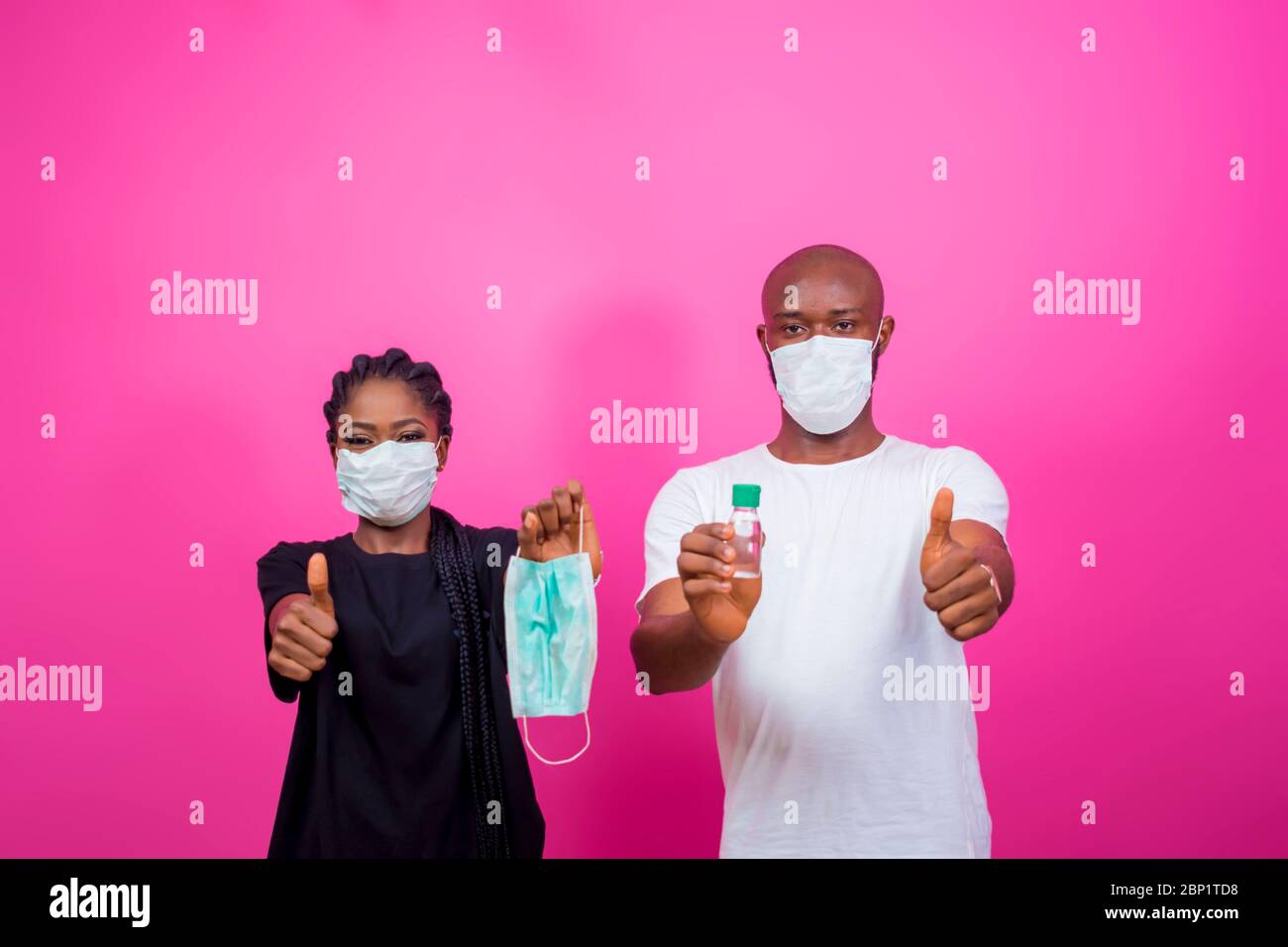 young black man and woman wearing nose masks and holding out nose mask ...