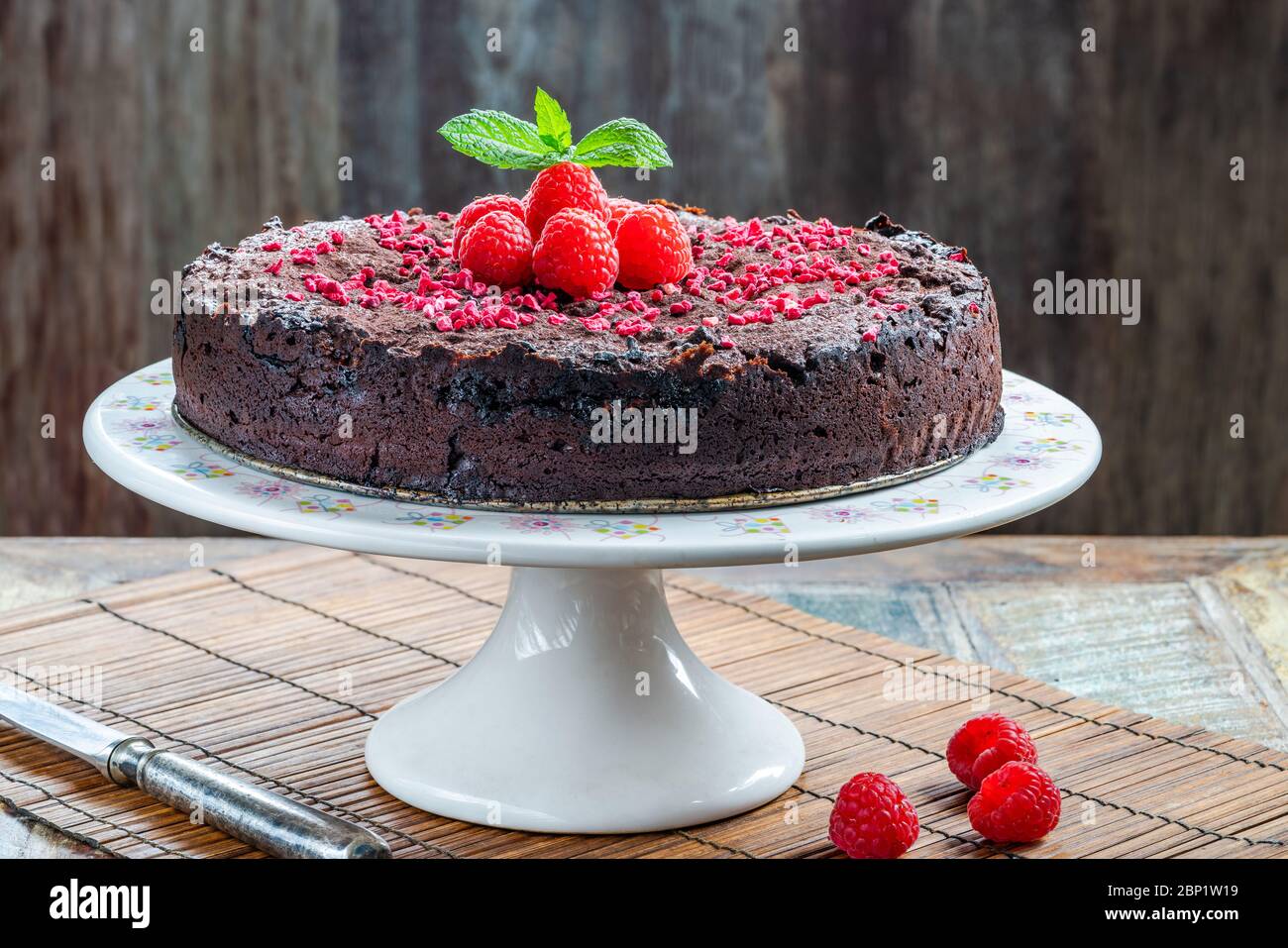 Chocolate and raspberry torte garnished with fresh fruit and mint Stock ...