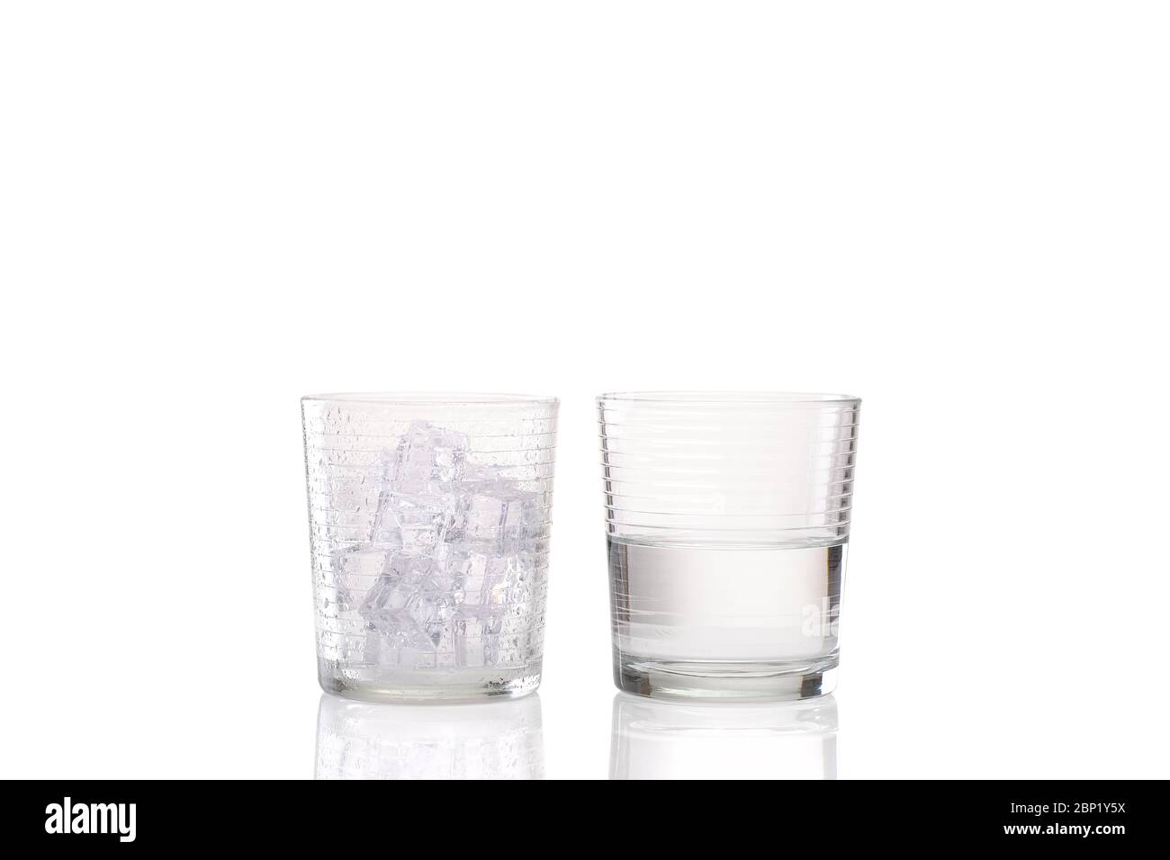 Ice melting concept with one tumbler glass with condensation droplets ...