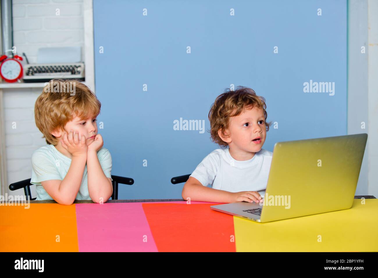 Happy cute industrious child is sitting at a desk indoors. Education ...