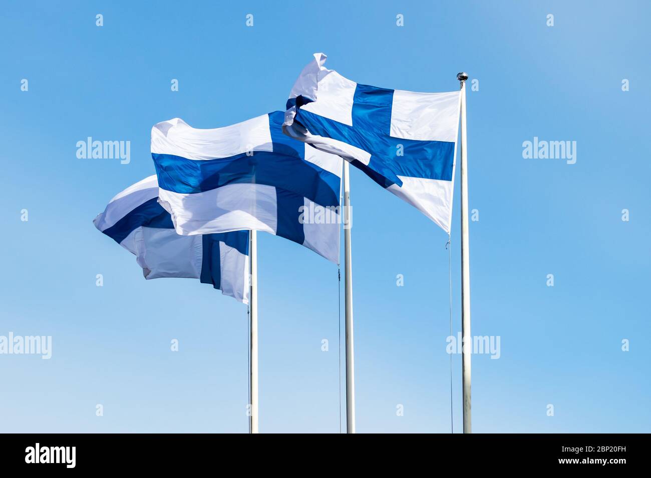 Three finnish national flags on the wind against the blue sky Stock ...