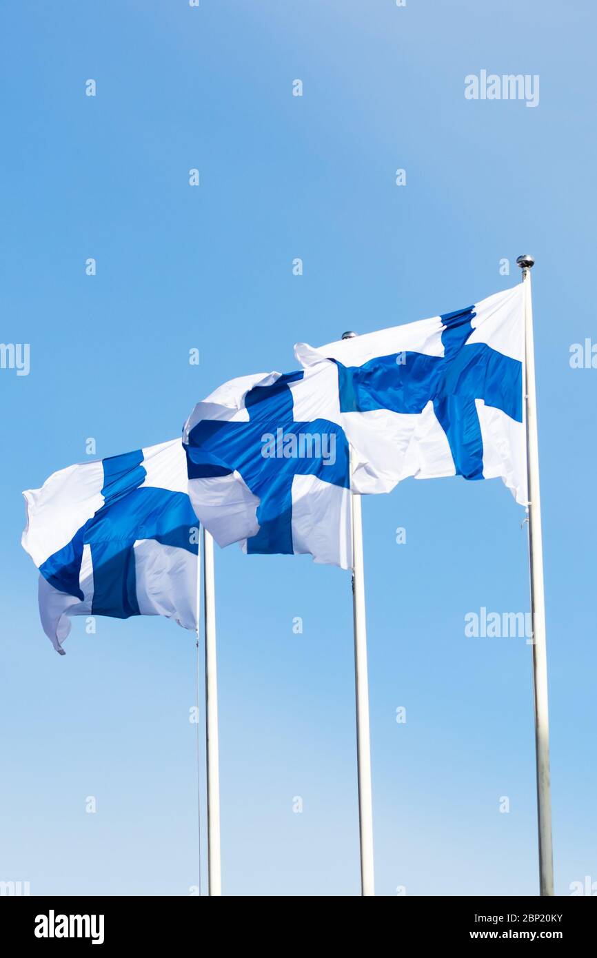 Three finnish national flags on the wind against the blue sky Stock ...