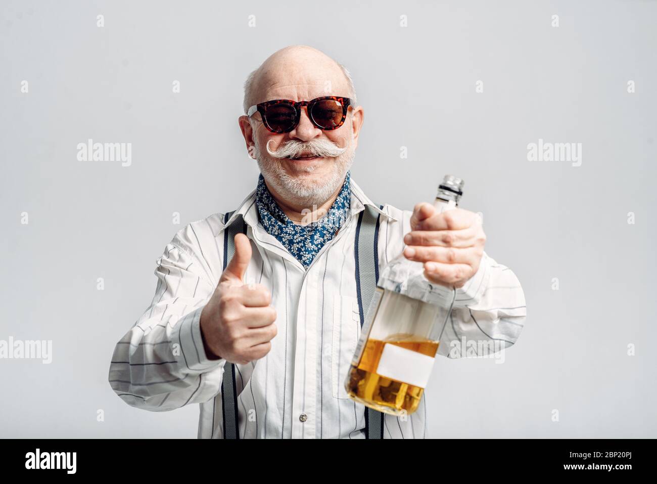 Elderly man holds the bottle of good alcohol Stock Photo - Alamy