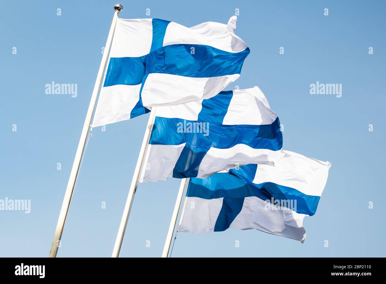 Three finnish national flags on the wind against the blue sky Stock ...