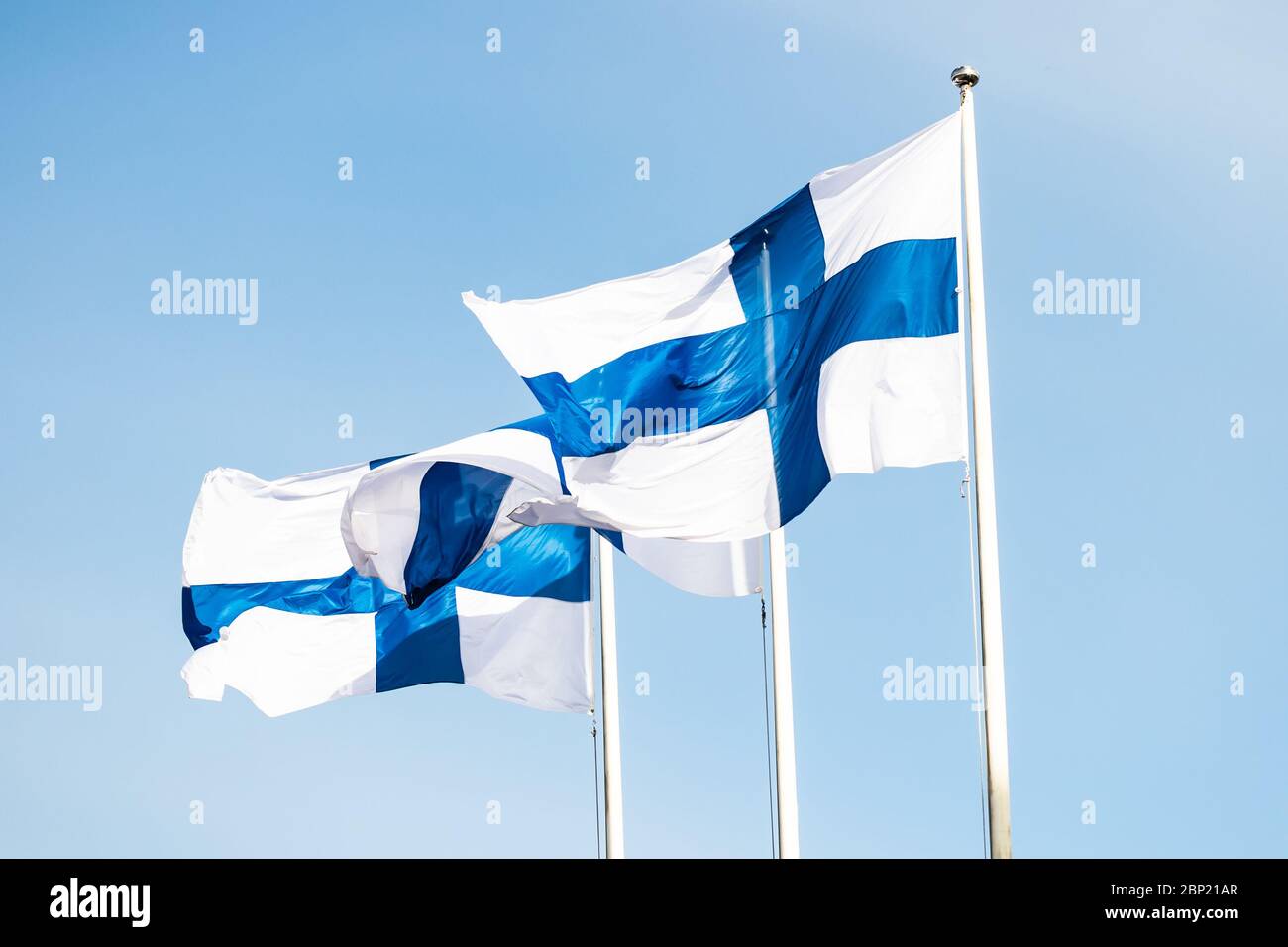 Three finnish national flags on the wind against the blue sky Stock ...