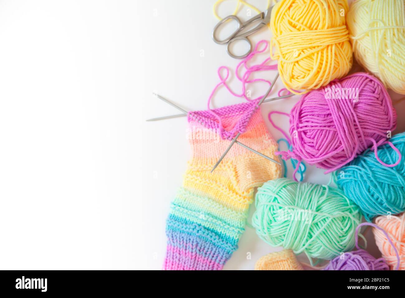 Knitted wool colored, rainbow striped socks. Skeins of yarn for ...