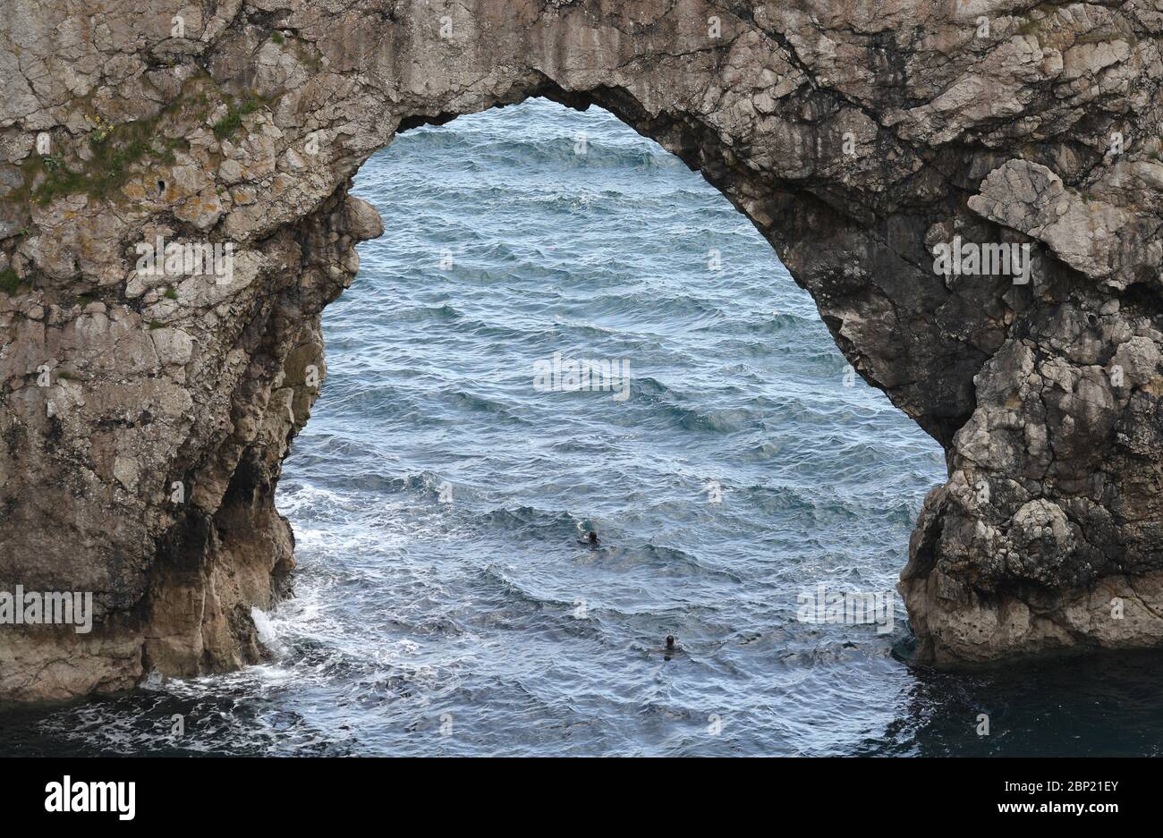 Two people swim under Durdle Door in Dorset Stock Photo - Alamy