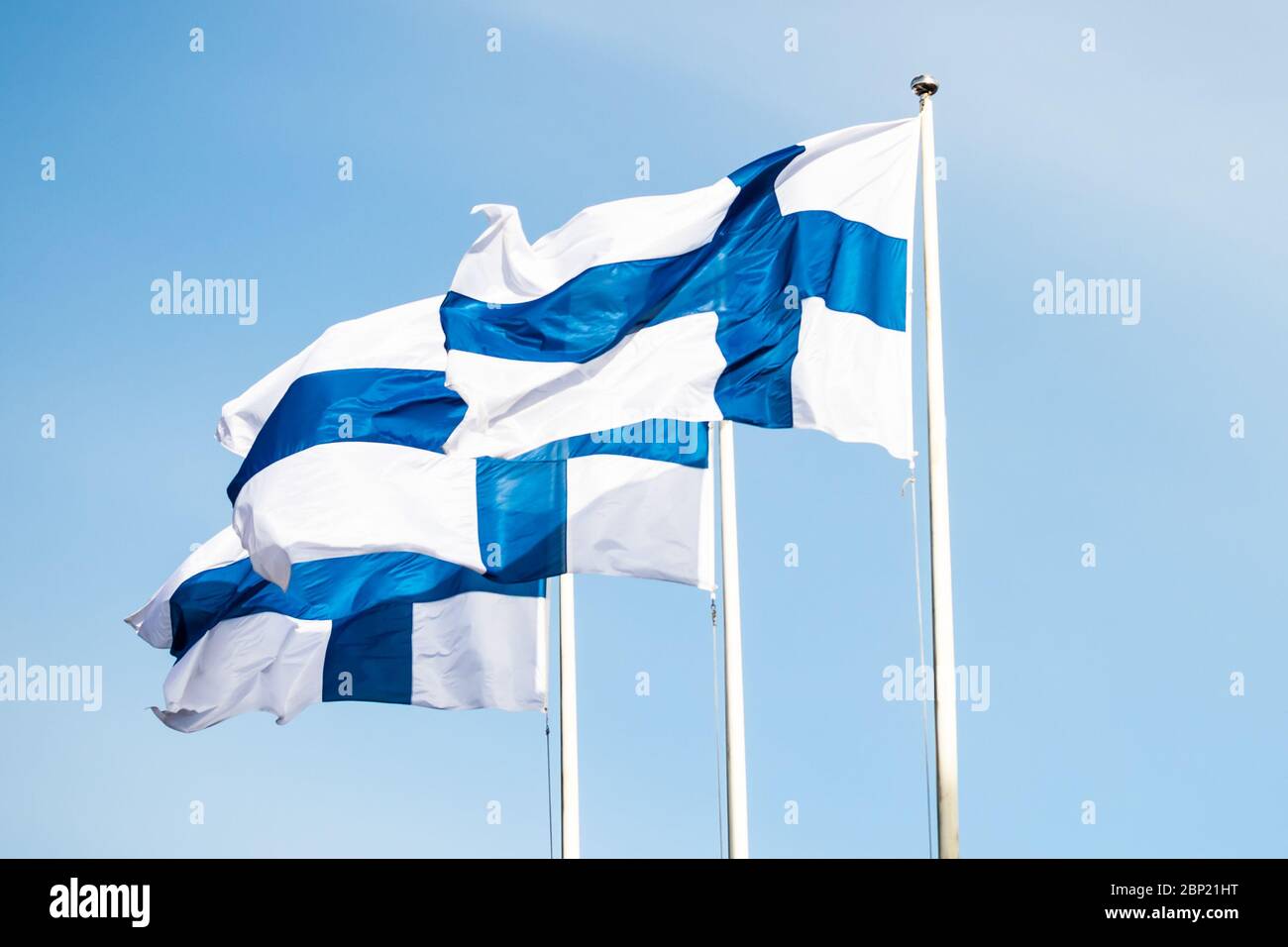 Three finnish national flags on the wind against the blue sky Stock ...
