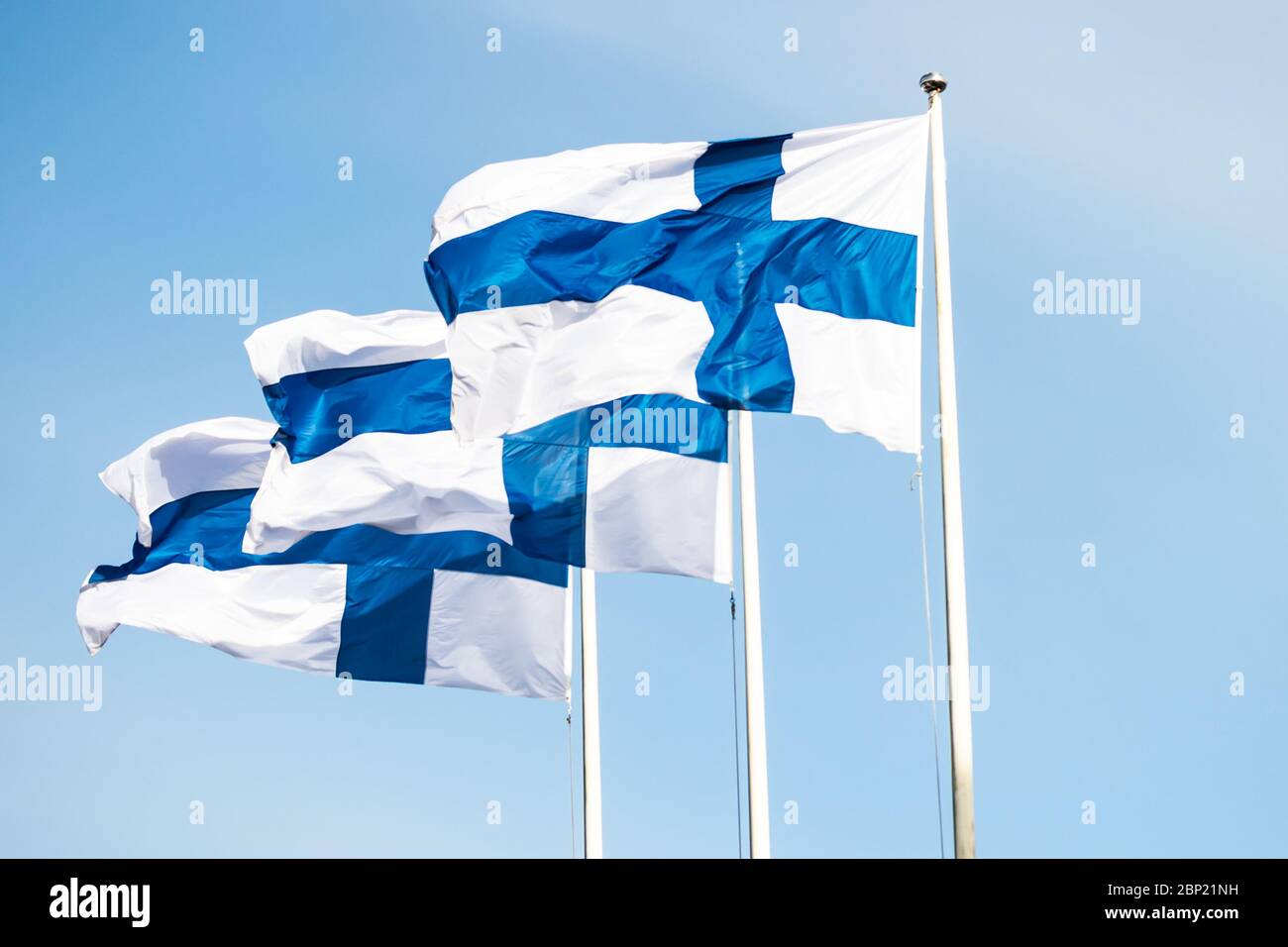 Three finnish national flags on the wind against the blue sky Stock ...