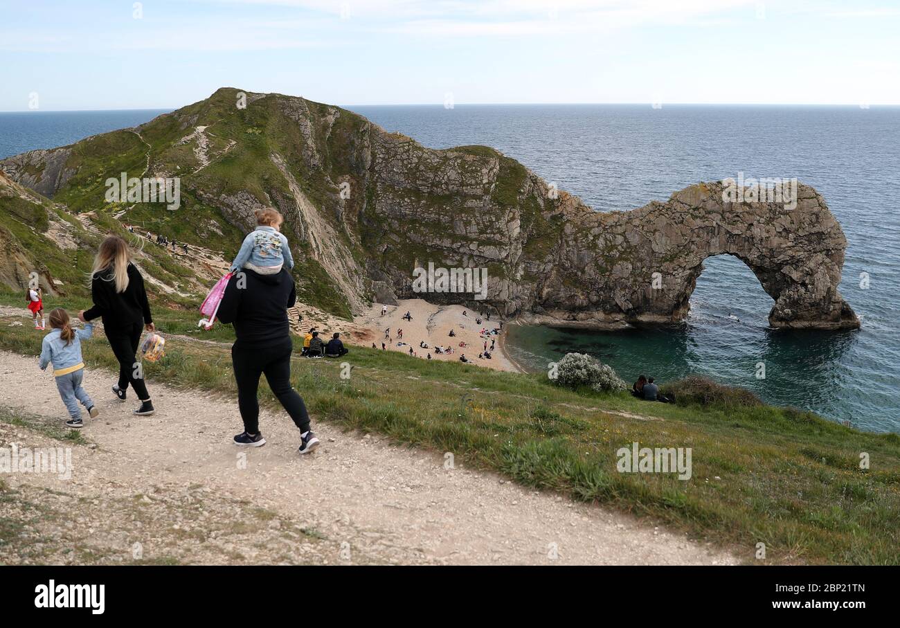 People walk along the cliff ledge above Durdle Door in Dorset Stock ...