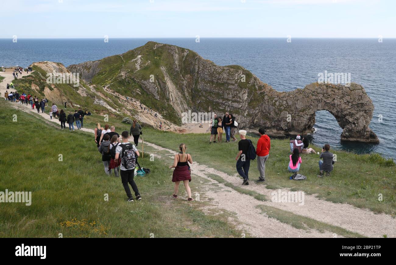 People walk along the cliff ledge above Durdle Door in Dorset Stock ...