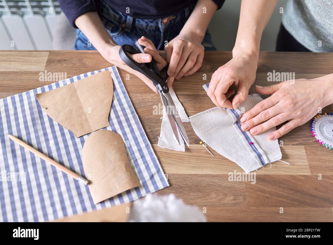 Sewing process close-up. Hands of woman and daughter sewing Stock Photo ...