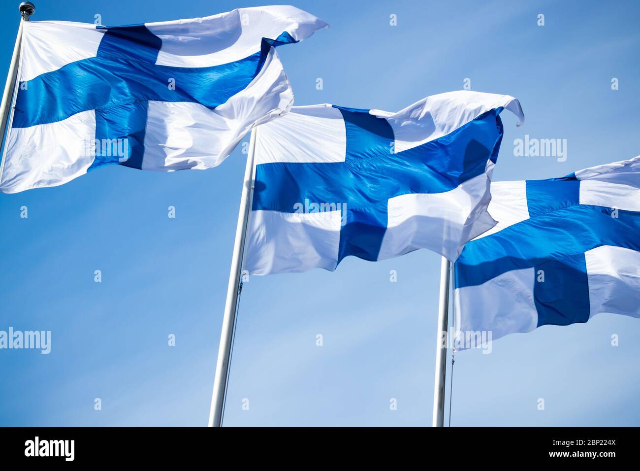 Three finnish national flags on the wind against the blue sky Stock ...