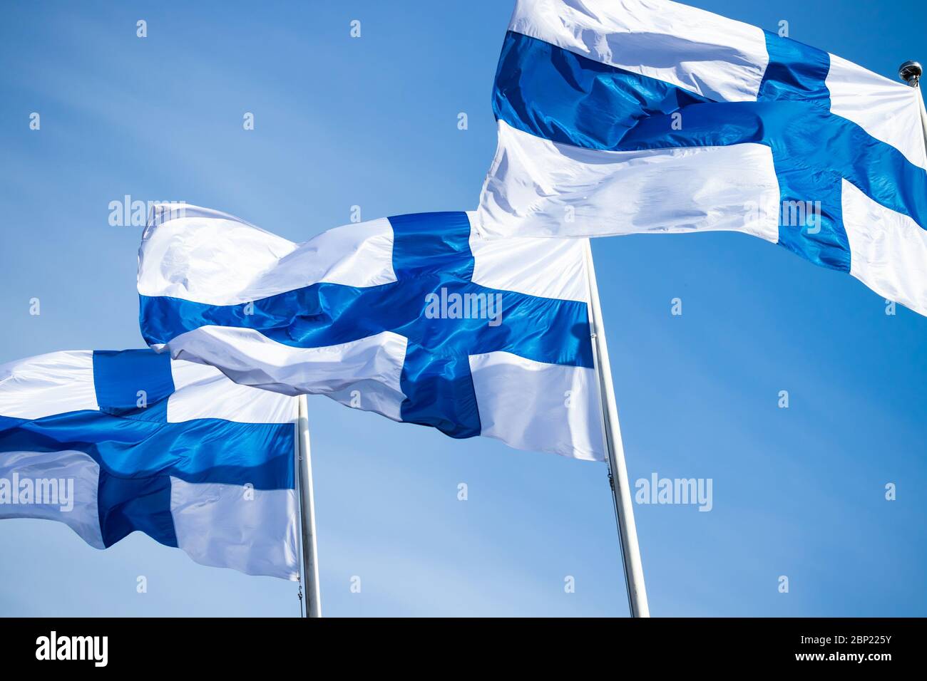Three finnish national flags on the wind against the blue sky Stock ...