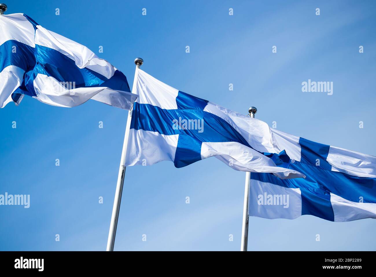 Three finnish national flags on the wind against the blue sky Stock ...