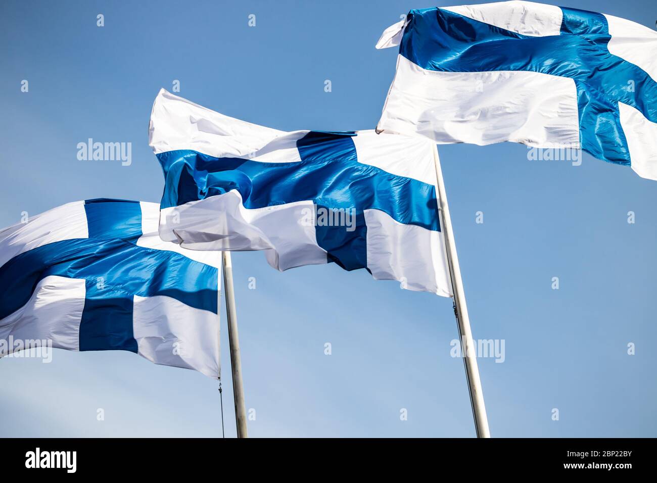 Three finnish national flags on the wind against the blue sky Stock ...