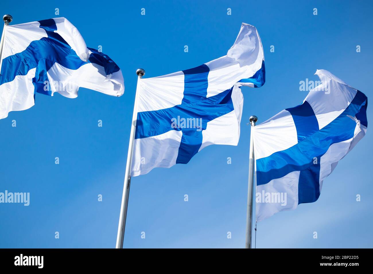 Three finnish national flags on the wind against the blue sky Stock ...
