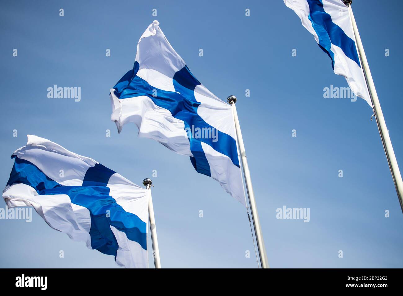 Three finnish national flags on the wind against the blue sky Stock ...