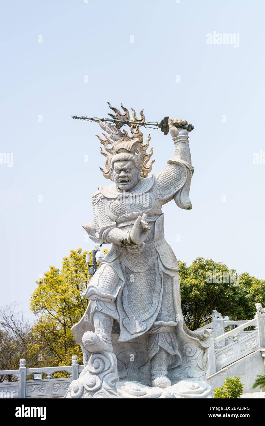 Statue of the Viruḍhaka Heavenly King in front of Golden statue of ...