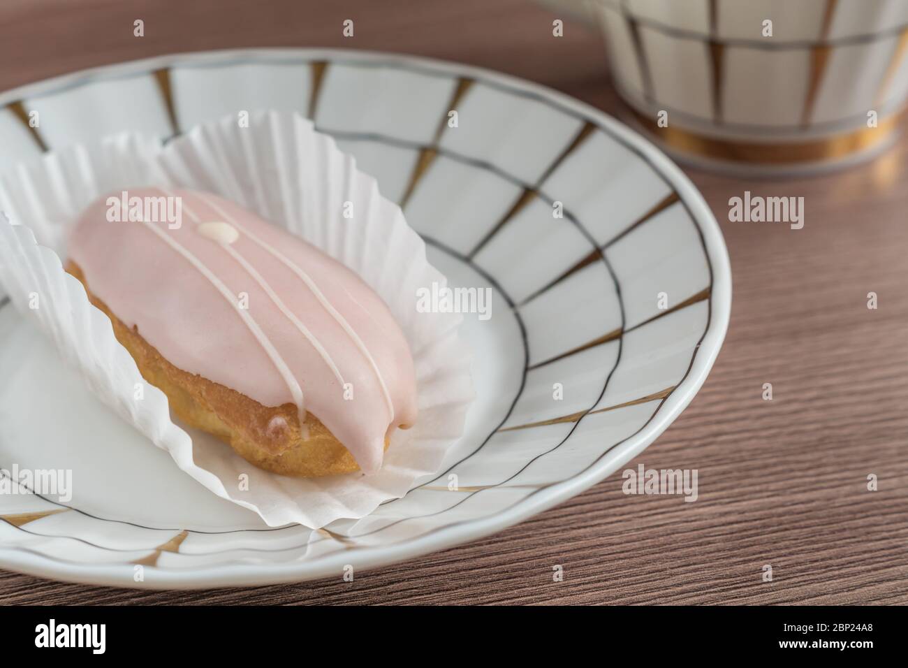 french eclairs on colorful porcelain plate on wooden table Stock Photo ...