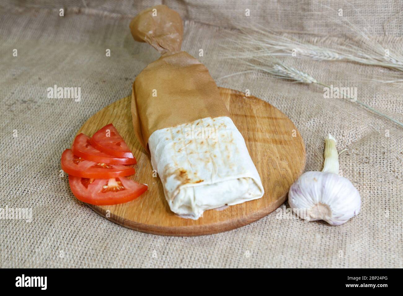 Asian traditional dish named shawarma with tomatoes and garlic on a ...