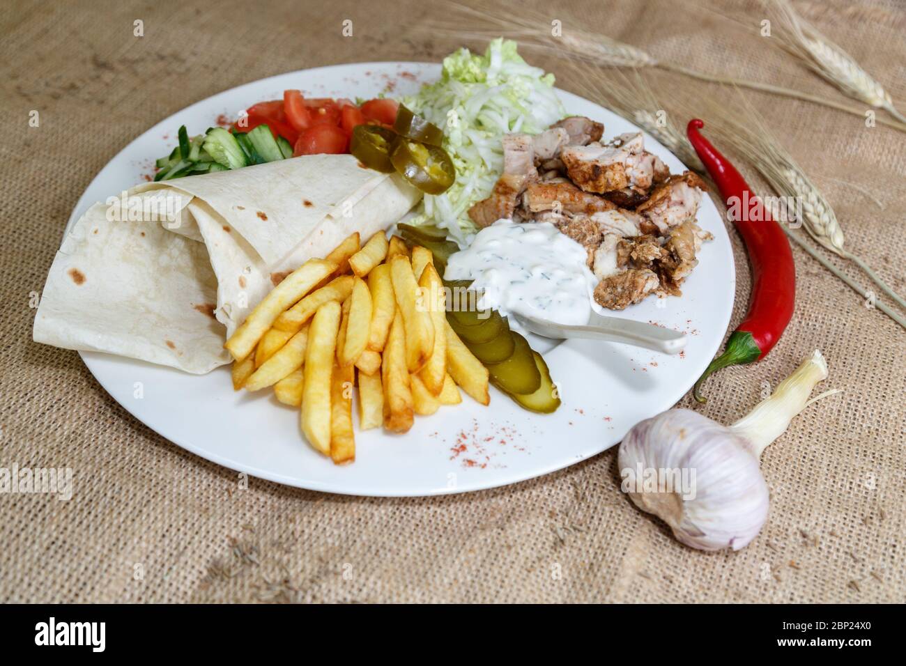 Asian traditional dish named shawarma with vegetables and bread on a ...