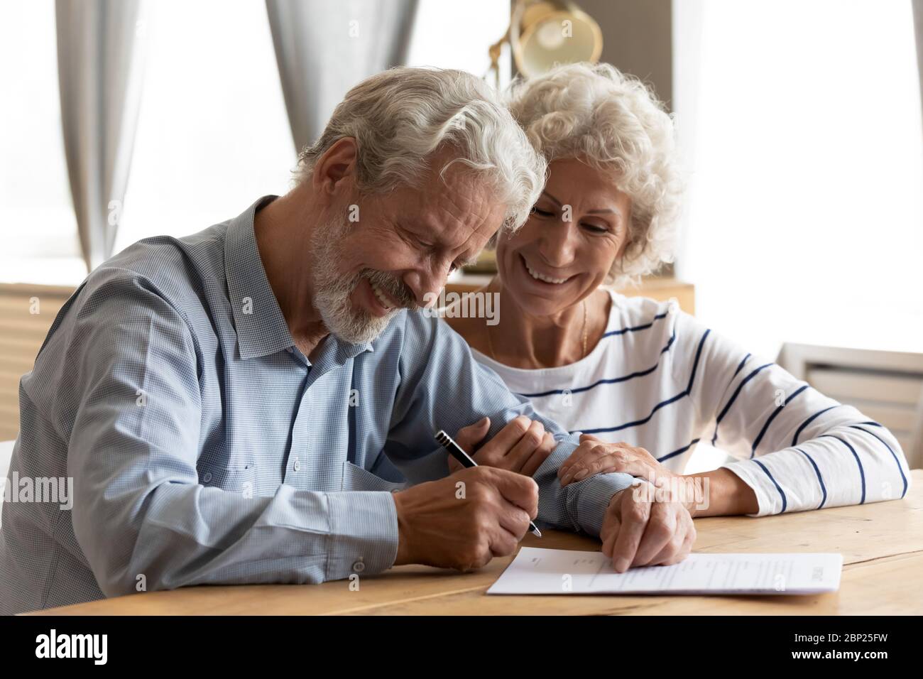 Happy middle aged retired couple signing marriage contract Stock Photo ... Happy middle aged retired couple signing marriage contract Stock Photo ...